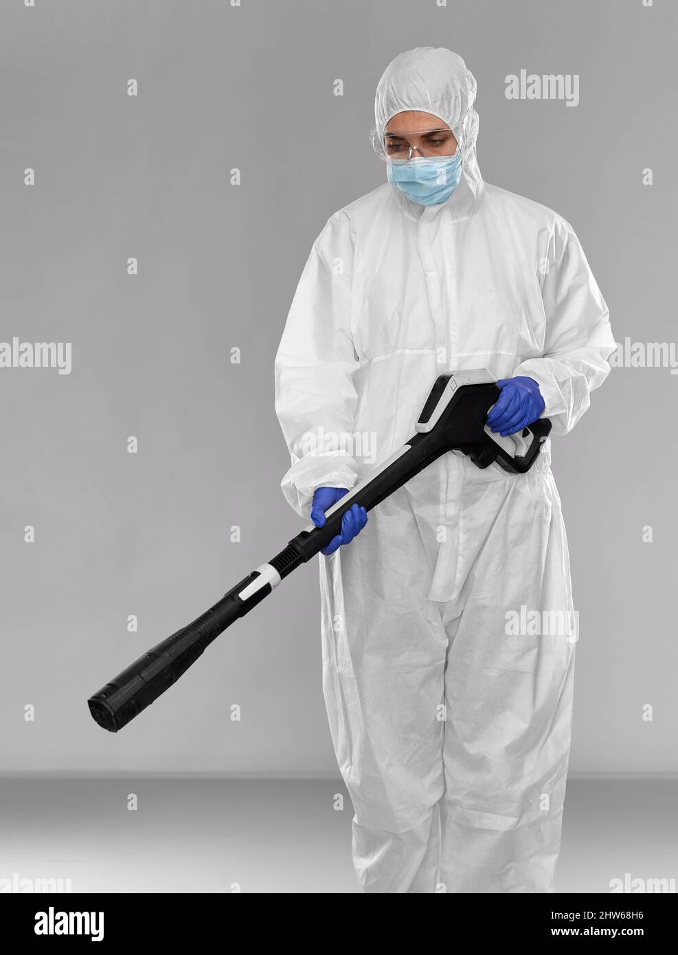 sanitation worker in hazmat with pressure washer Stock Photo - Alamy