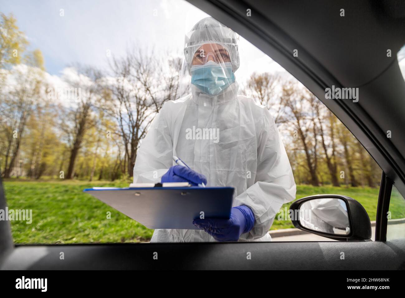 doctor in hazmat suit with clipboard at car Stock Photo - Alamy