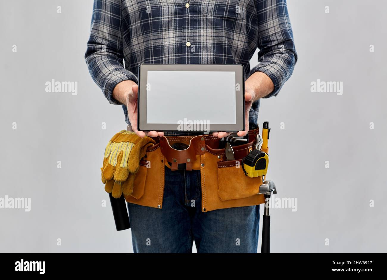male builder with working tools showing tablet pc Stock Photo - Alamy