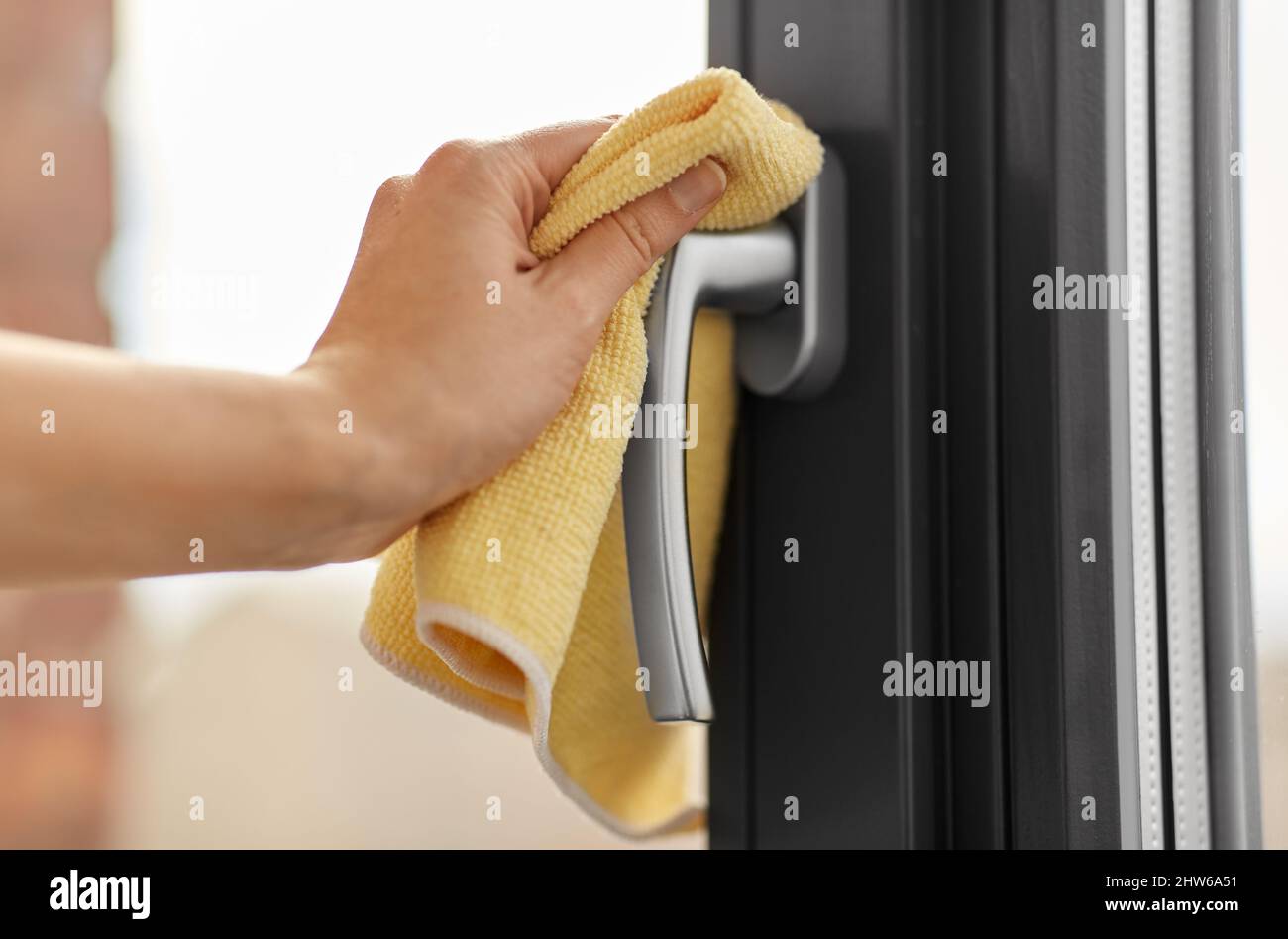 hand cleaning window handle with microfiber rag Stock Photo - Alamy
