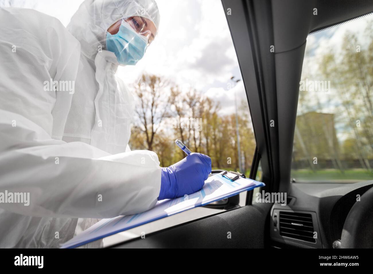 doctor in hazmat suit with clipboard at car Stock Photo - Alamy