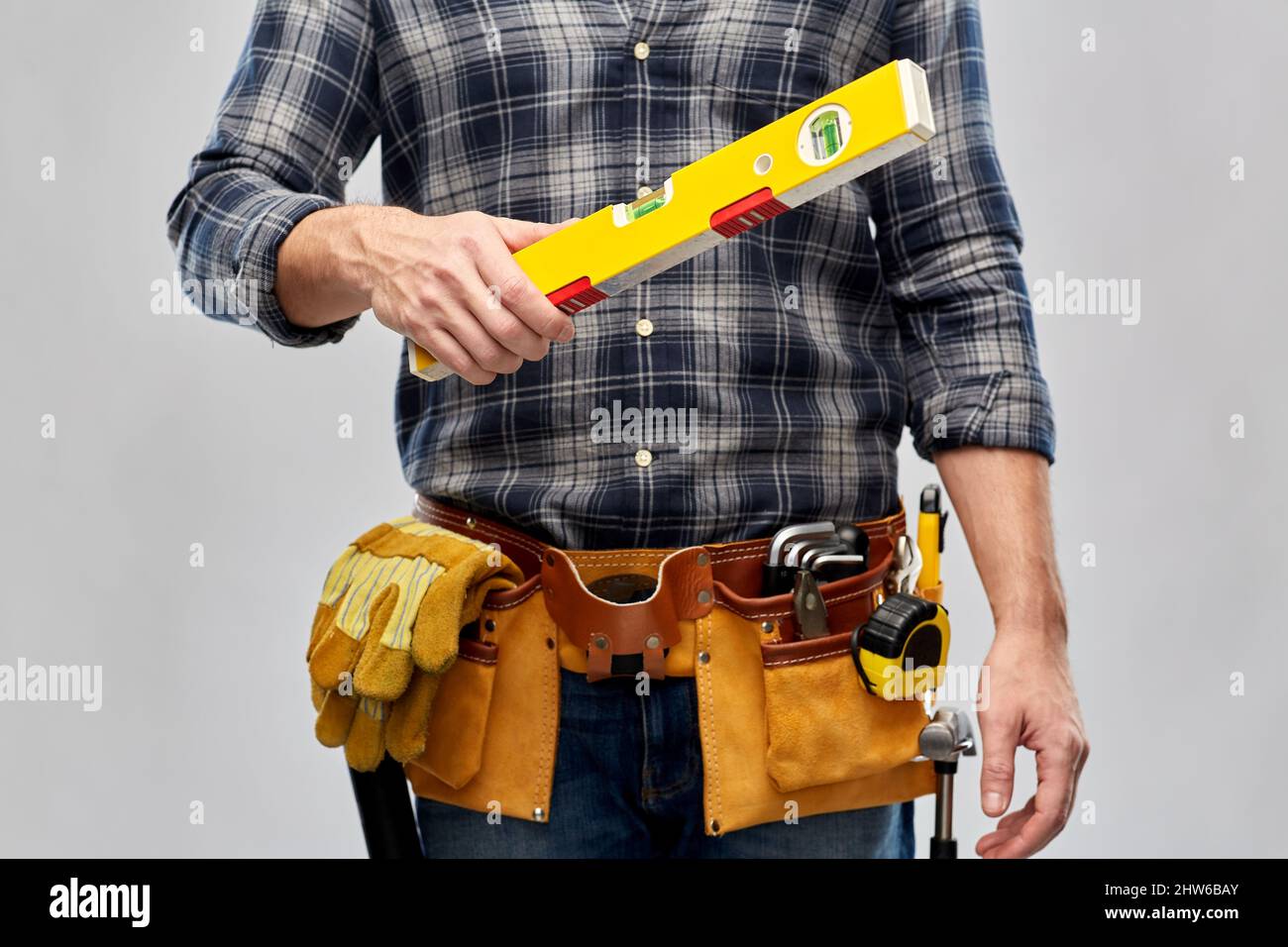 male builder with level and working tools on belt Stock Photo - Alamy
