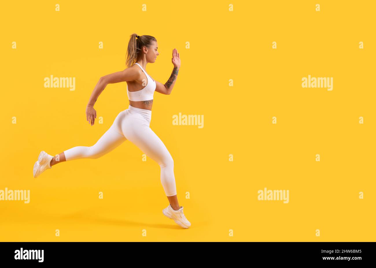 sport girl runner running on yellow background. copy space Stock Photo ...