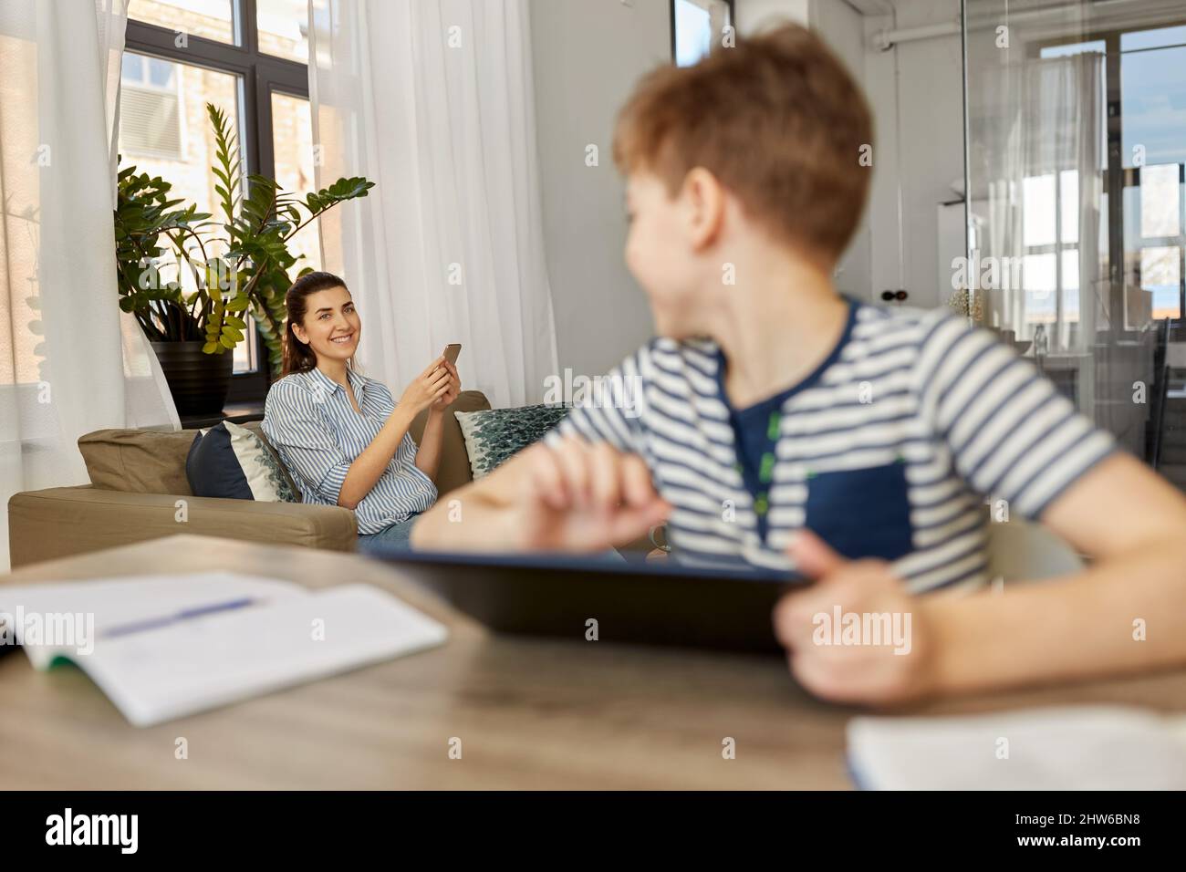 mother with smartphone talking to son at home Stock Photo - Alamy