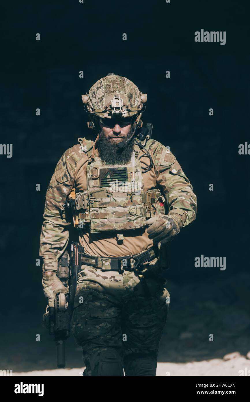 A bearded soldier in a special forces uniform walks through an ...