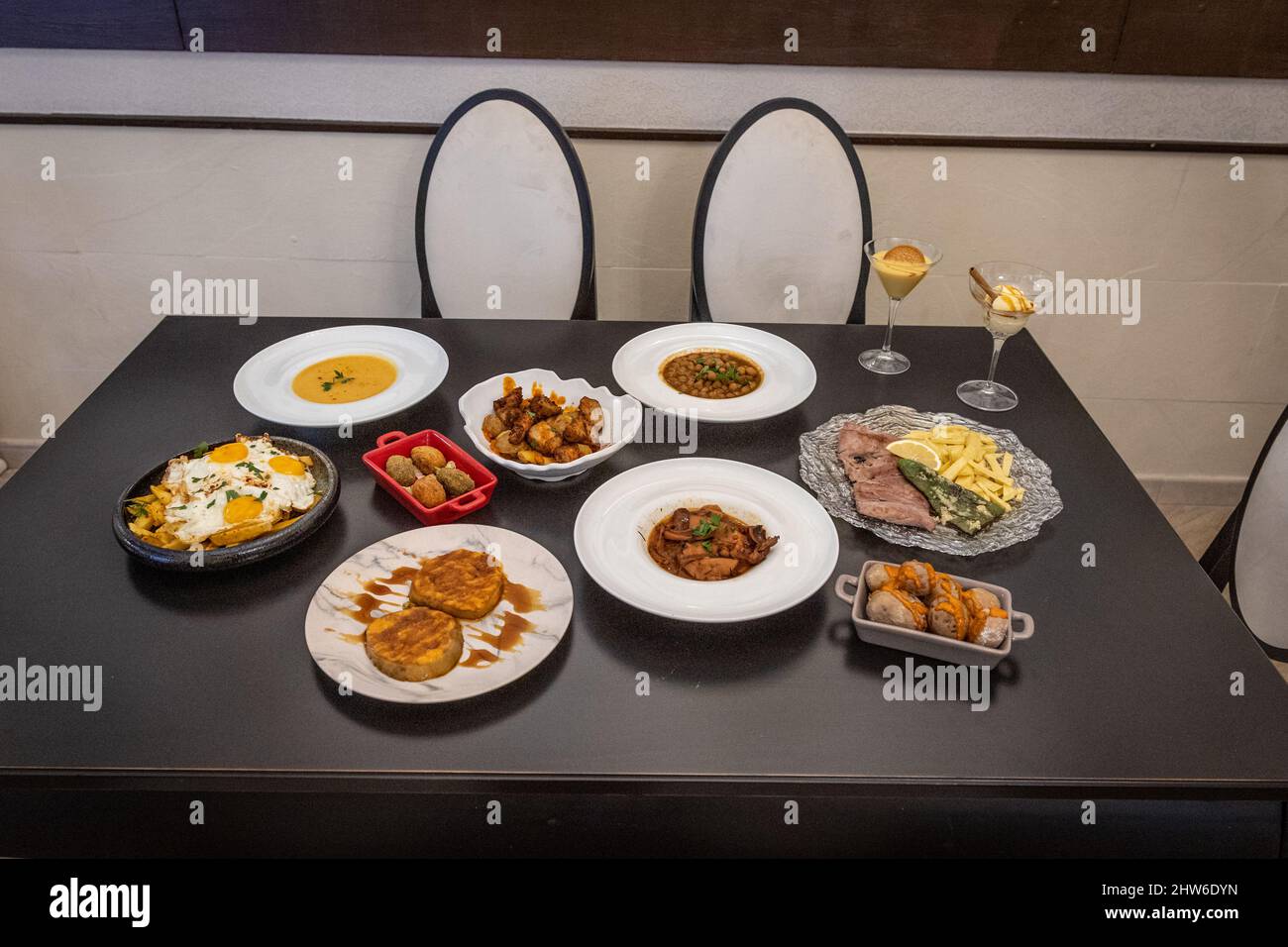 Big wooden table has several types of cooked delicious food in ...