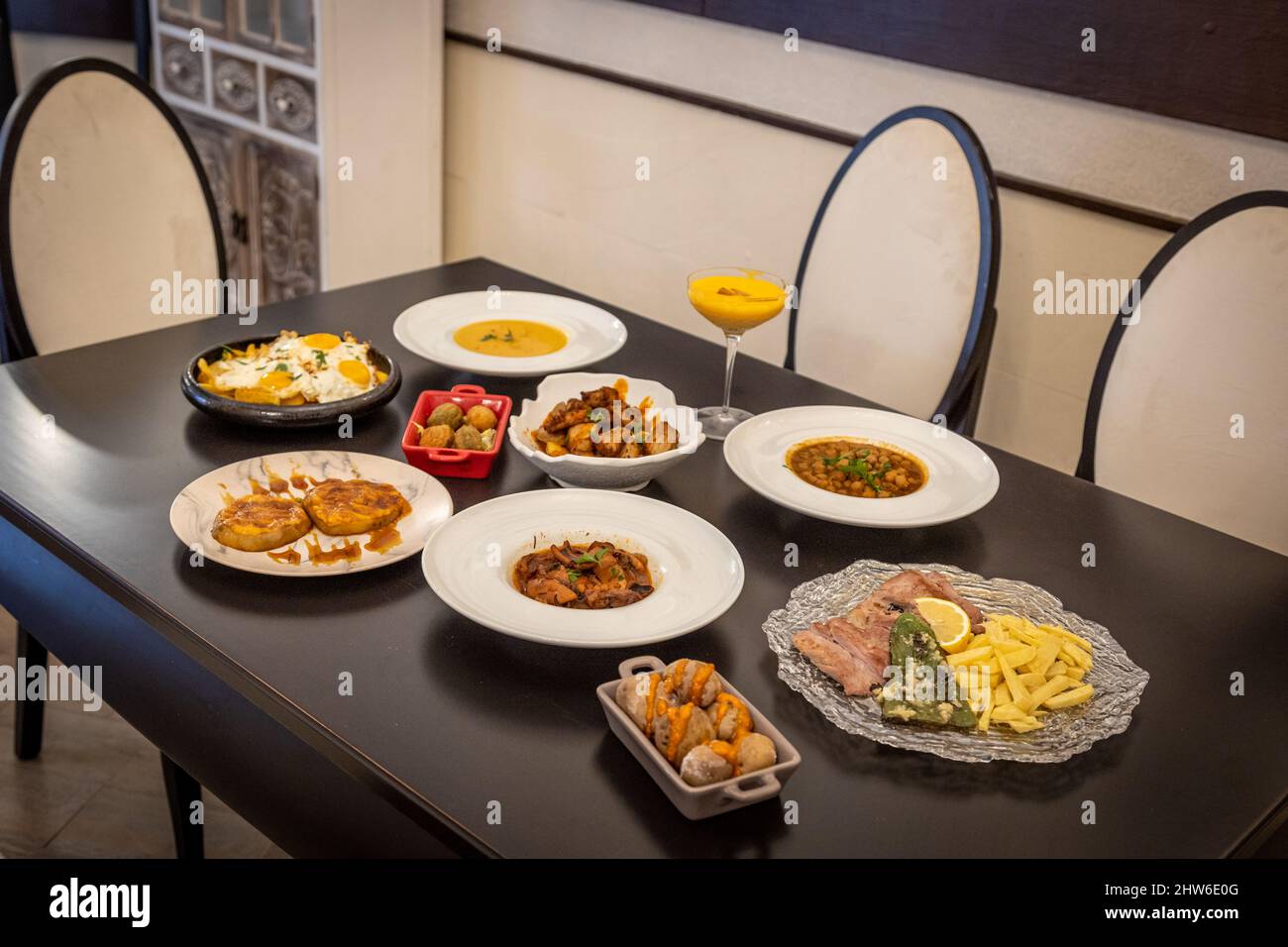 Big wooden table has several types of cooked delicious food in ...