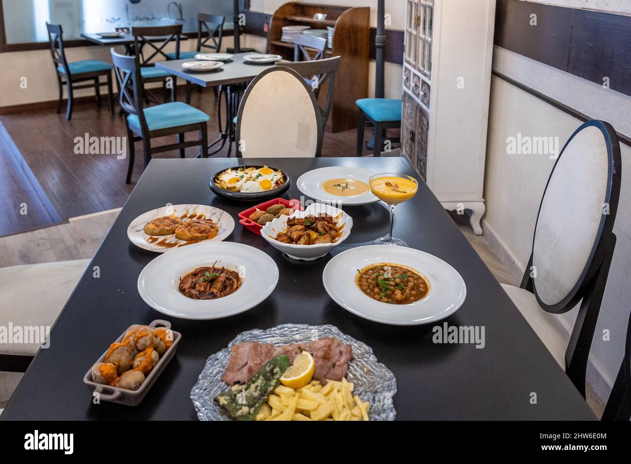 Big wooden table has several types of cooked delicious food in ...