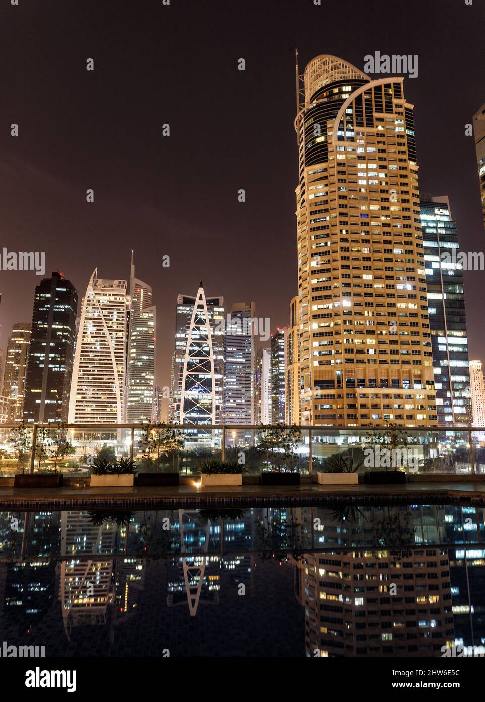 Vertical shot of high-rise buildings reflected in water in Dubai at ...