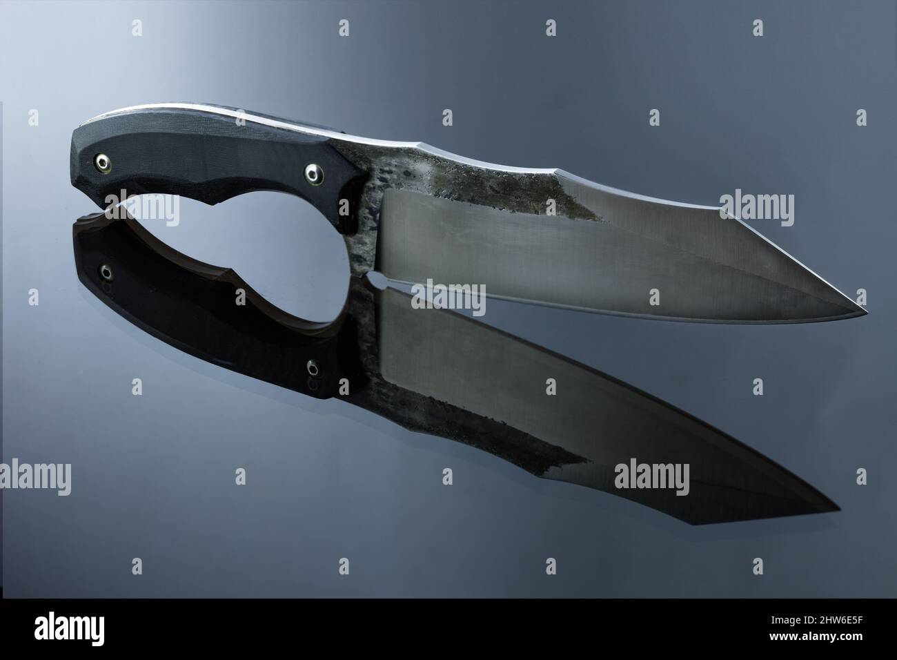 All-metal, tactical, kitchen knife on a mirror surface, handwork, steel ...