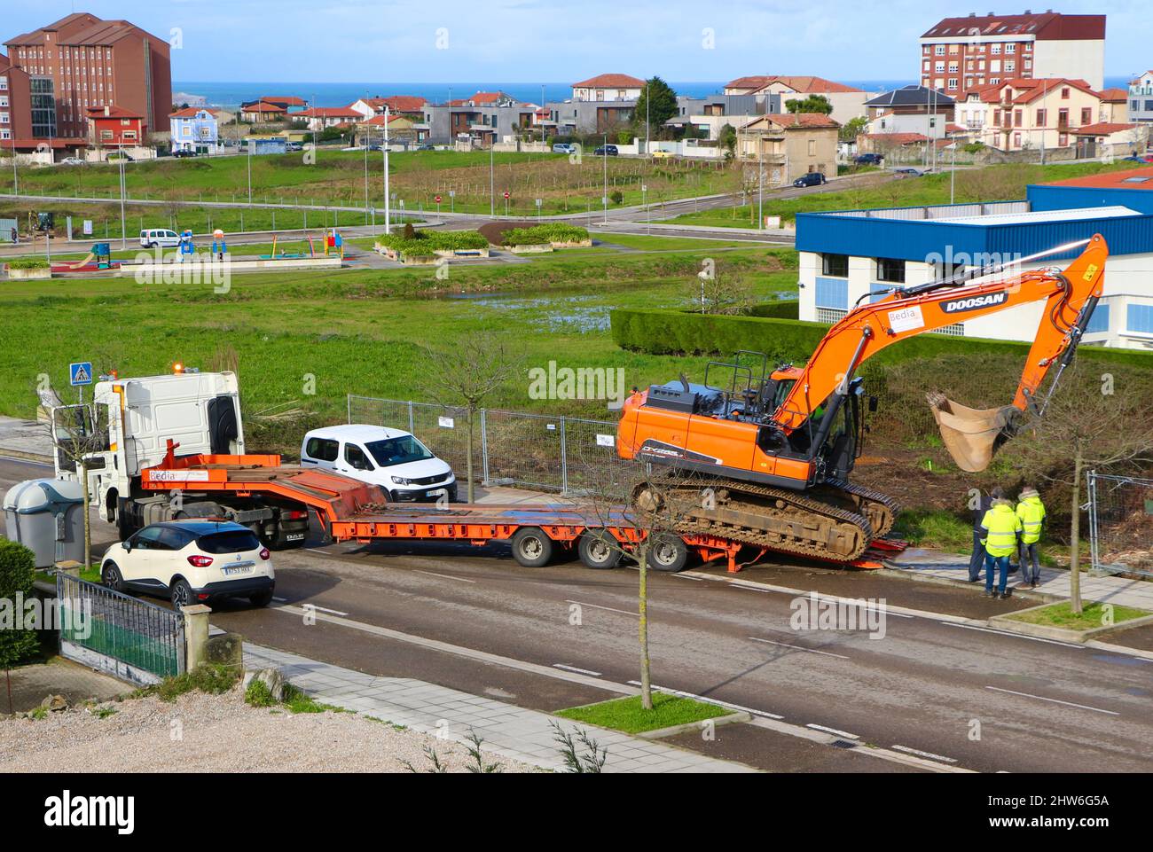 A Doosan orange digger being offloaded from a low loader trailer for ...