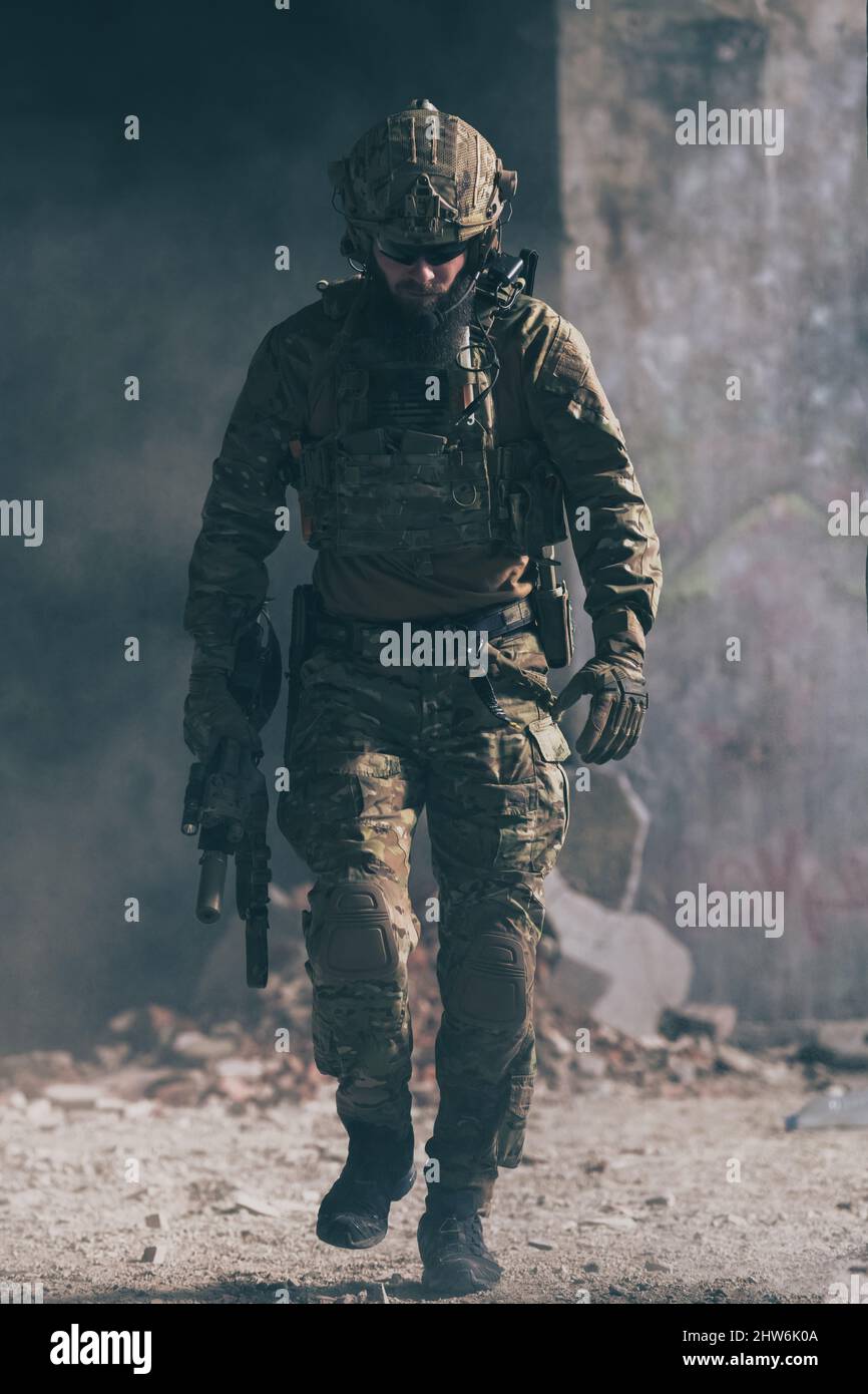 A bearded soldier in a special forces uniform walks through an ...