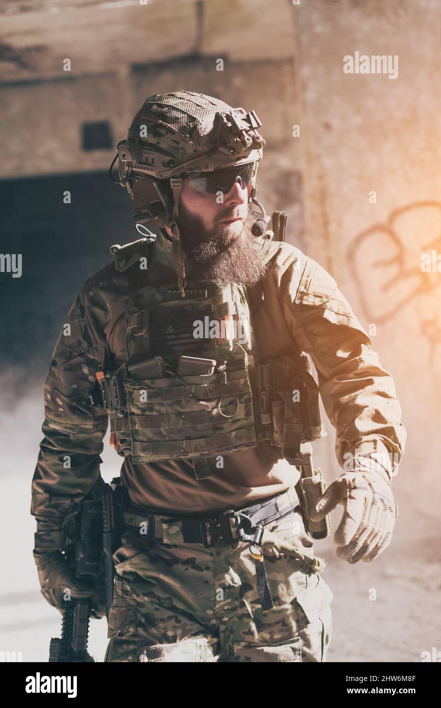 A bearded soldier in a special forces uniform walks through an ...