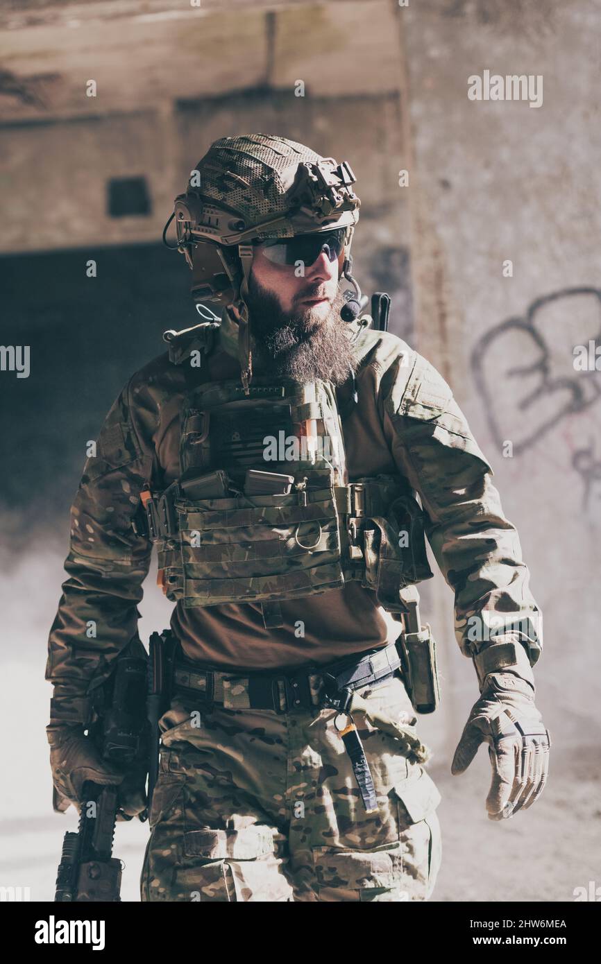 A bearded soldier in a special forces uniform walks through an ...