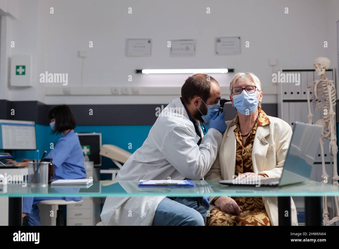 Health expert using otoscope to consult retired patient at medical ...