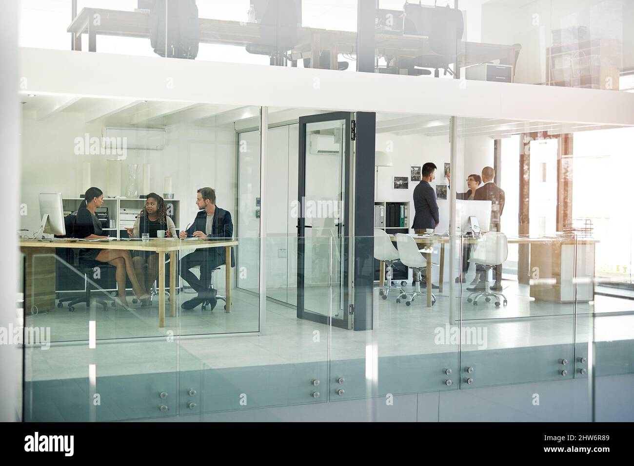 The inner workings of a modern office. Full length shot of two groups ...