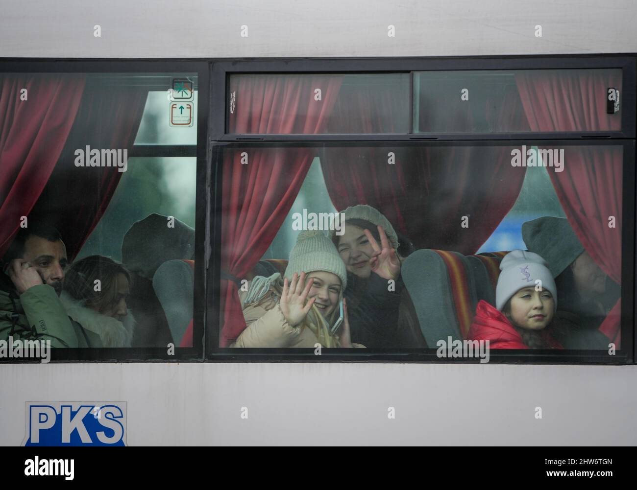 Korczowa, Poland. 04th Mar, 2022. Refugees wave out of the window at ...