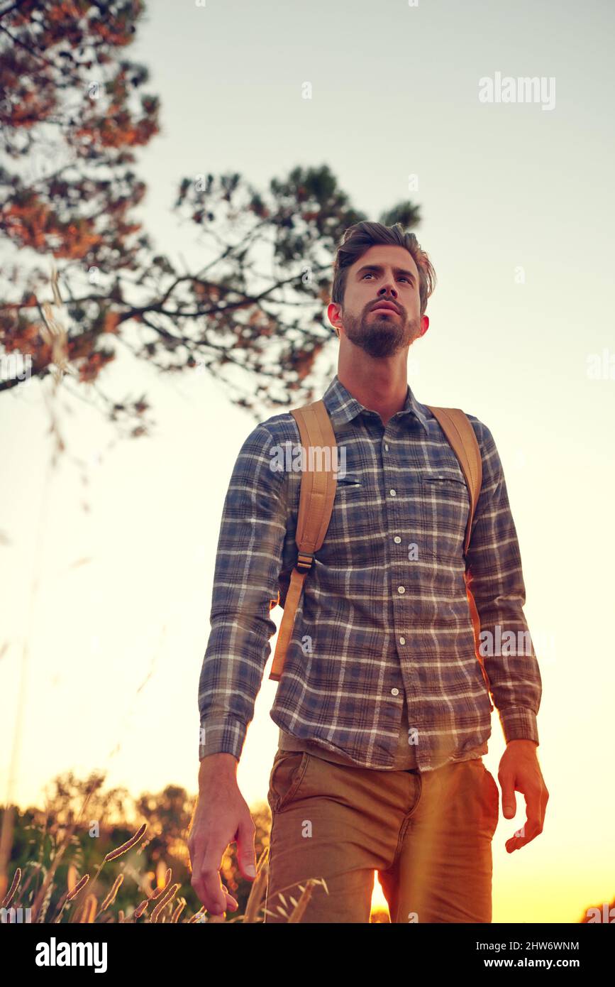The perfect day for a hike. Shot of a handsome young man enjoying a ...