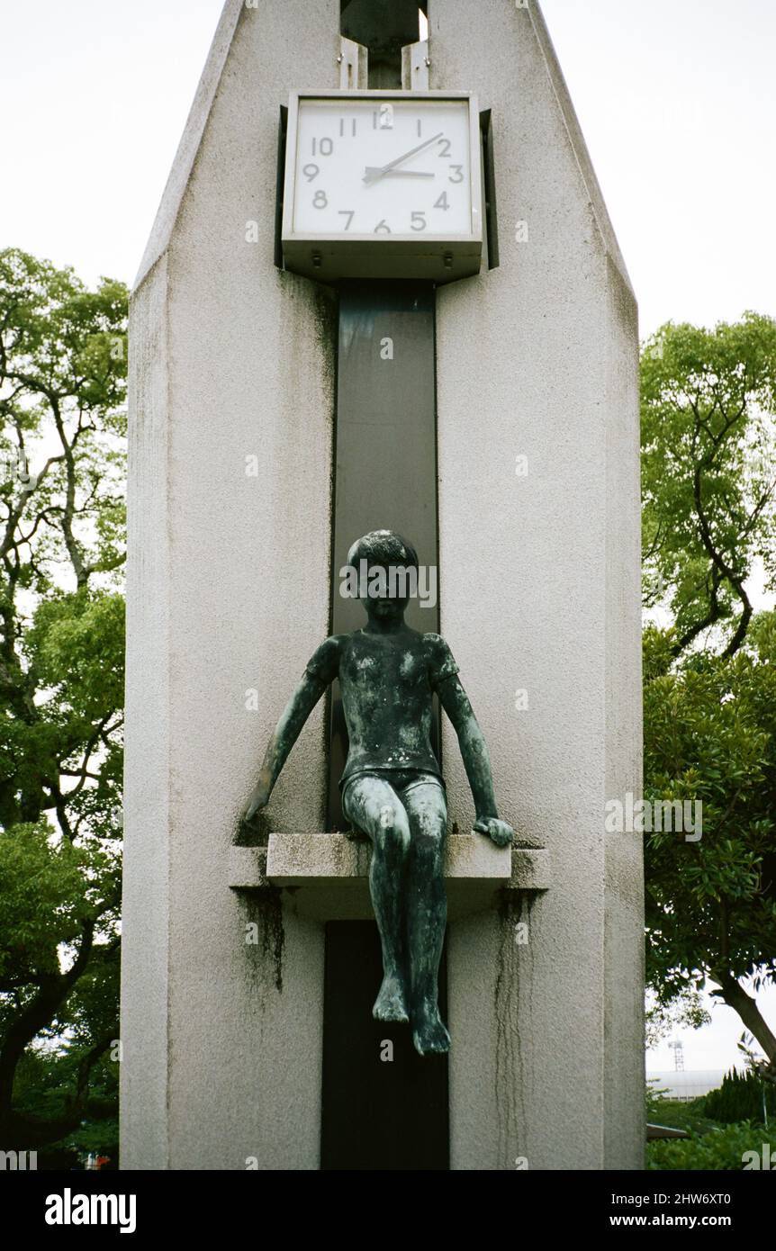 Vertical shot of a clock statue monument with a boy child statue in ...