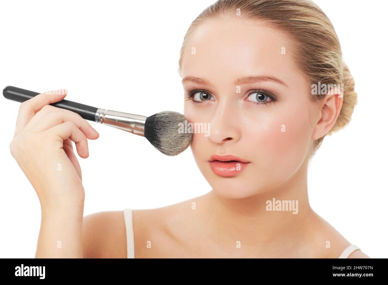 Cosmetics elevate her natural beauty. A beautiful young woman applying ...