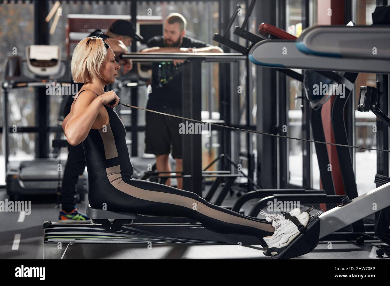 Attractive young fitness model works out on training apparatus inside ...