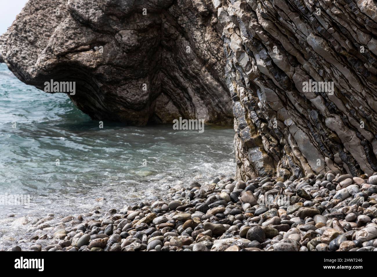Waves splashing at rocks at the beach Stock Photo - Alamy