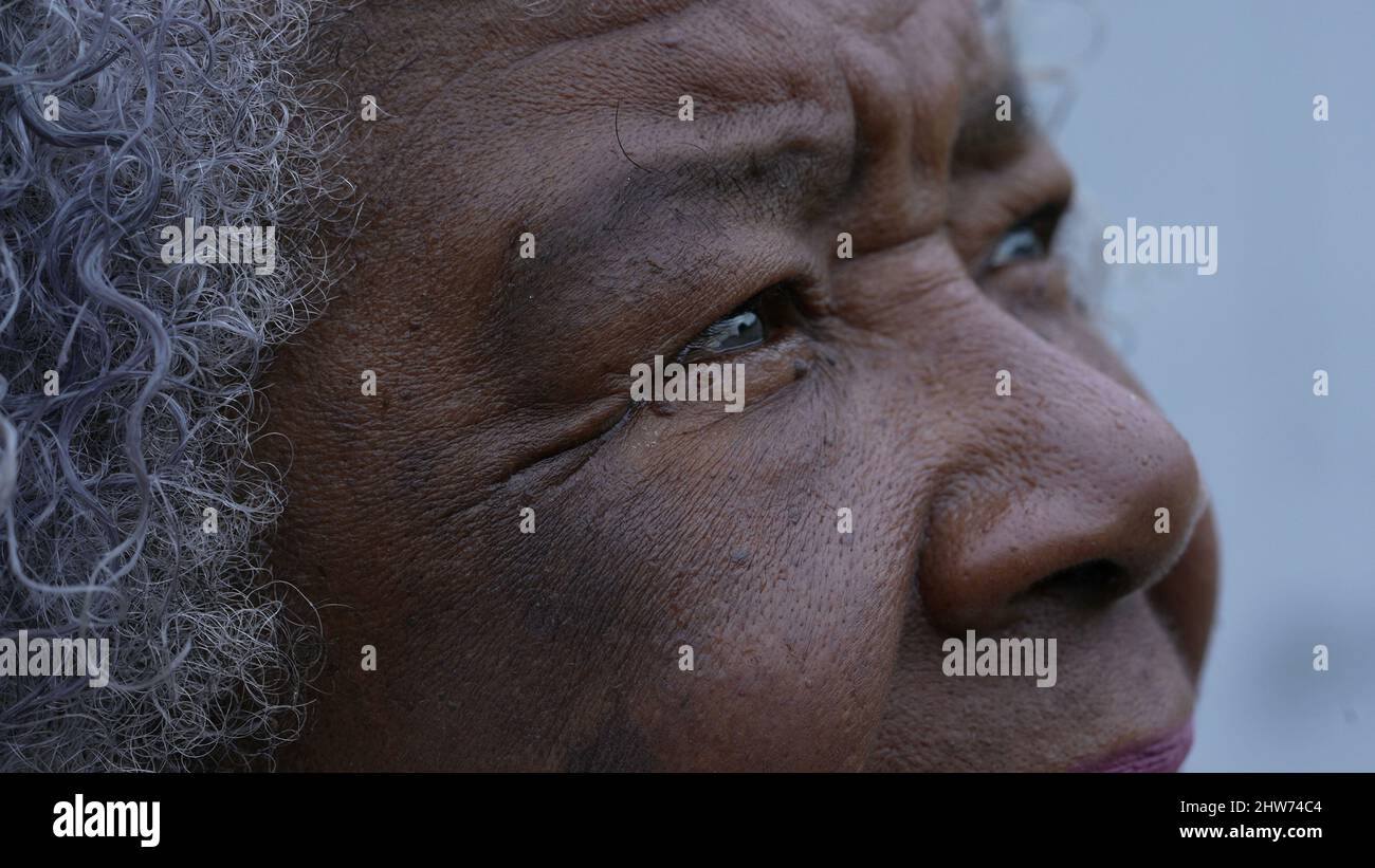 An African older woman looking up at sky with HOPE and FAITH macro eyes ...