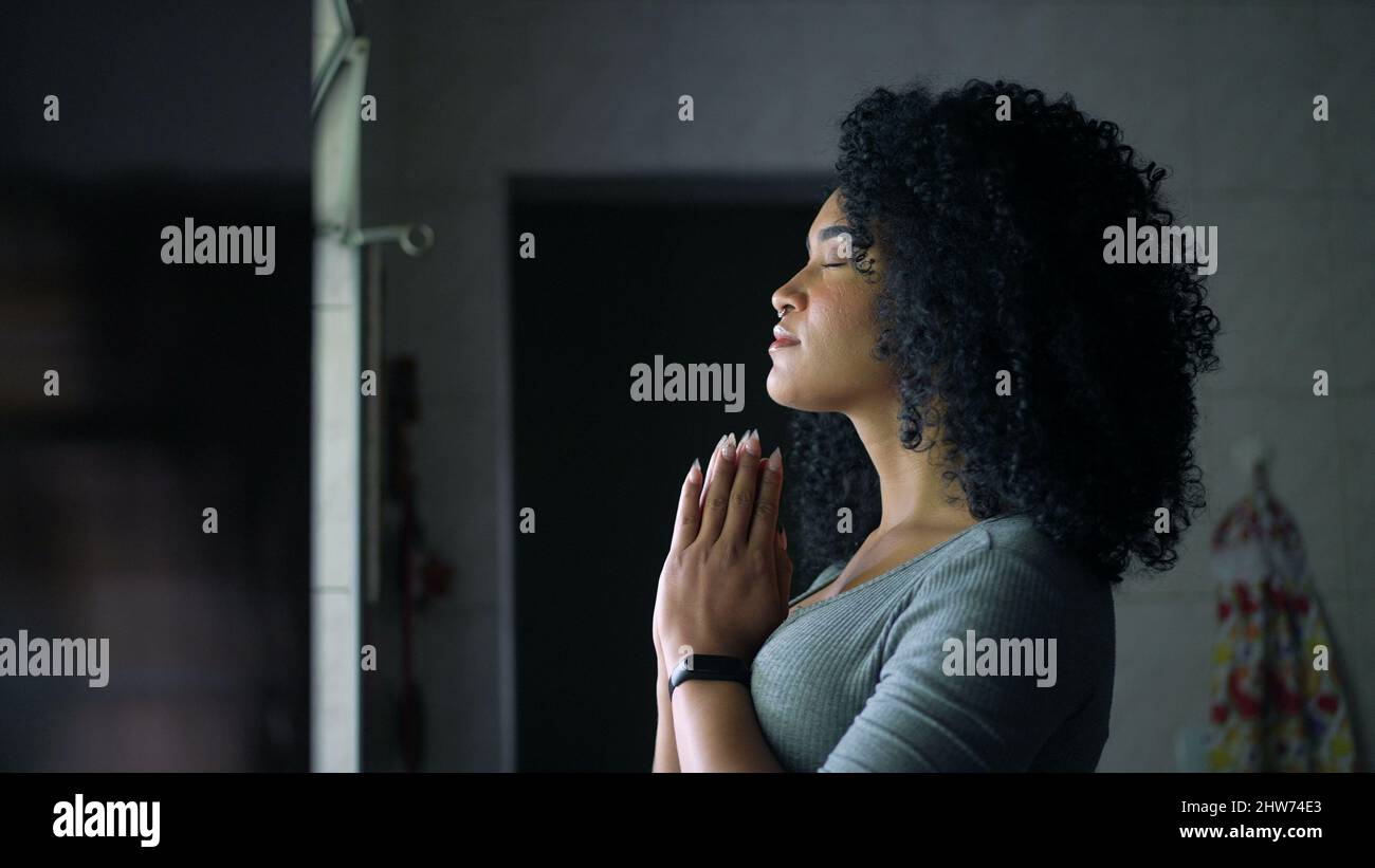 An African woman praying to God standing at home by window Stock Photo ...