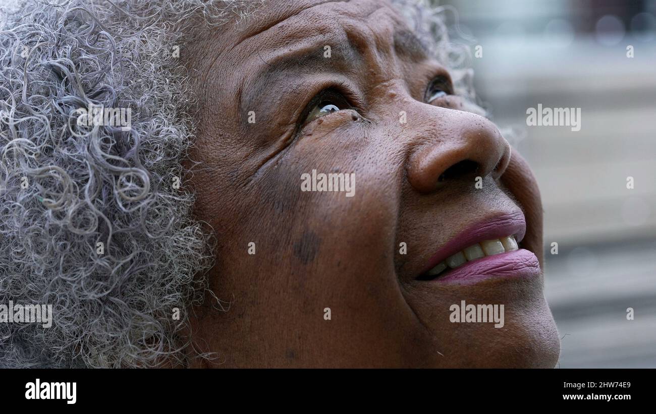 An African woman opening eyes to sky smiling with HOPE Stock Photo - Alamy