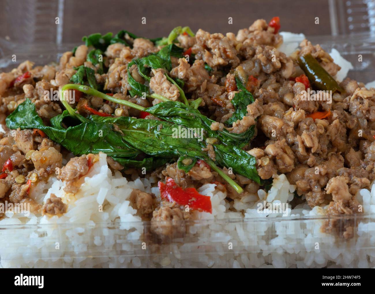 Close-up view of basil fried rice with minced pork in a plastic box ...