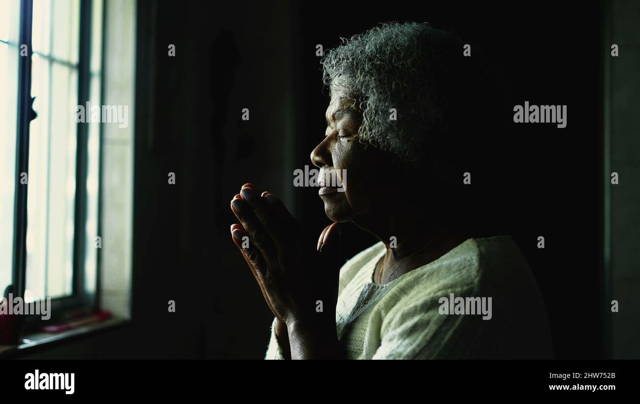 Spiritual older woman in 80s praying at home by window Stock Photo - Alamy