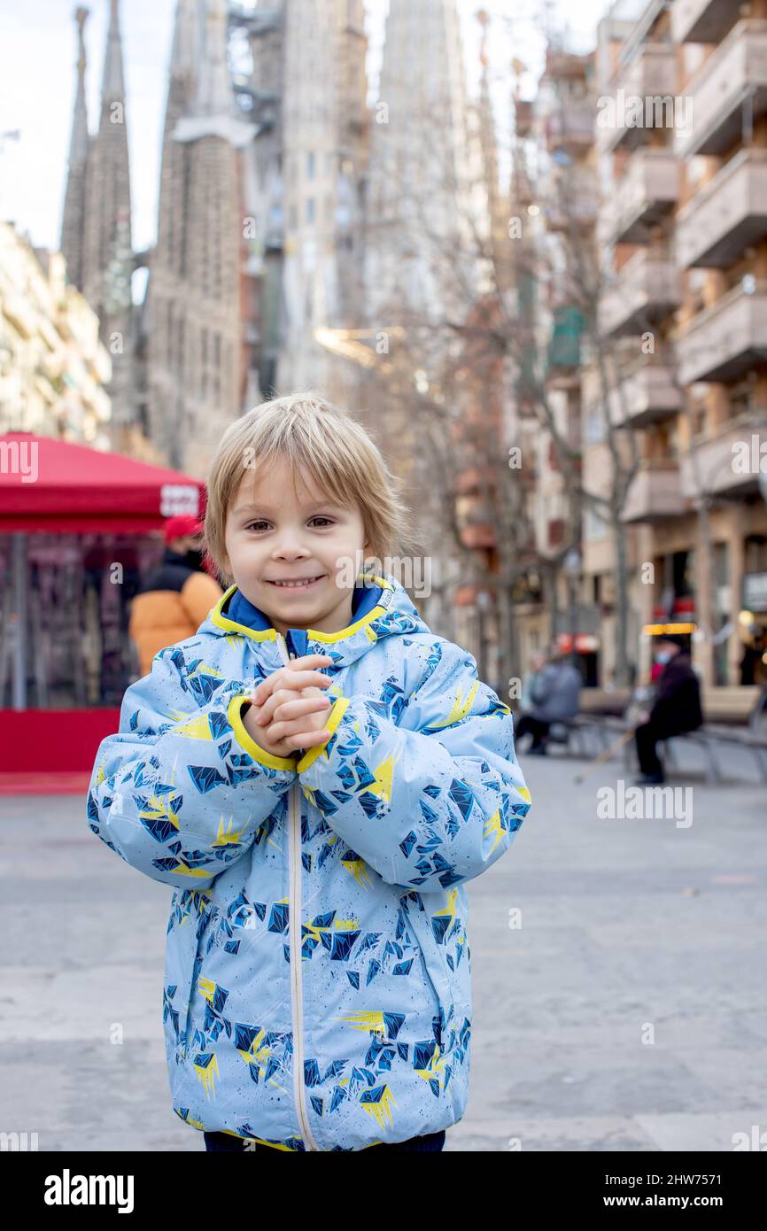 Cute little child tourists admiring Familia Sagrada in Barcelona city ...