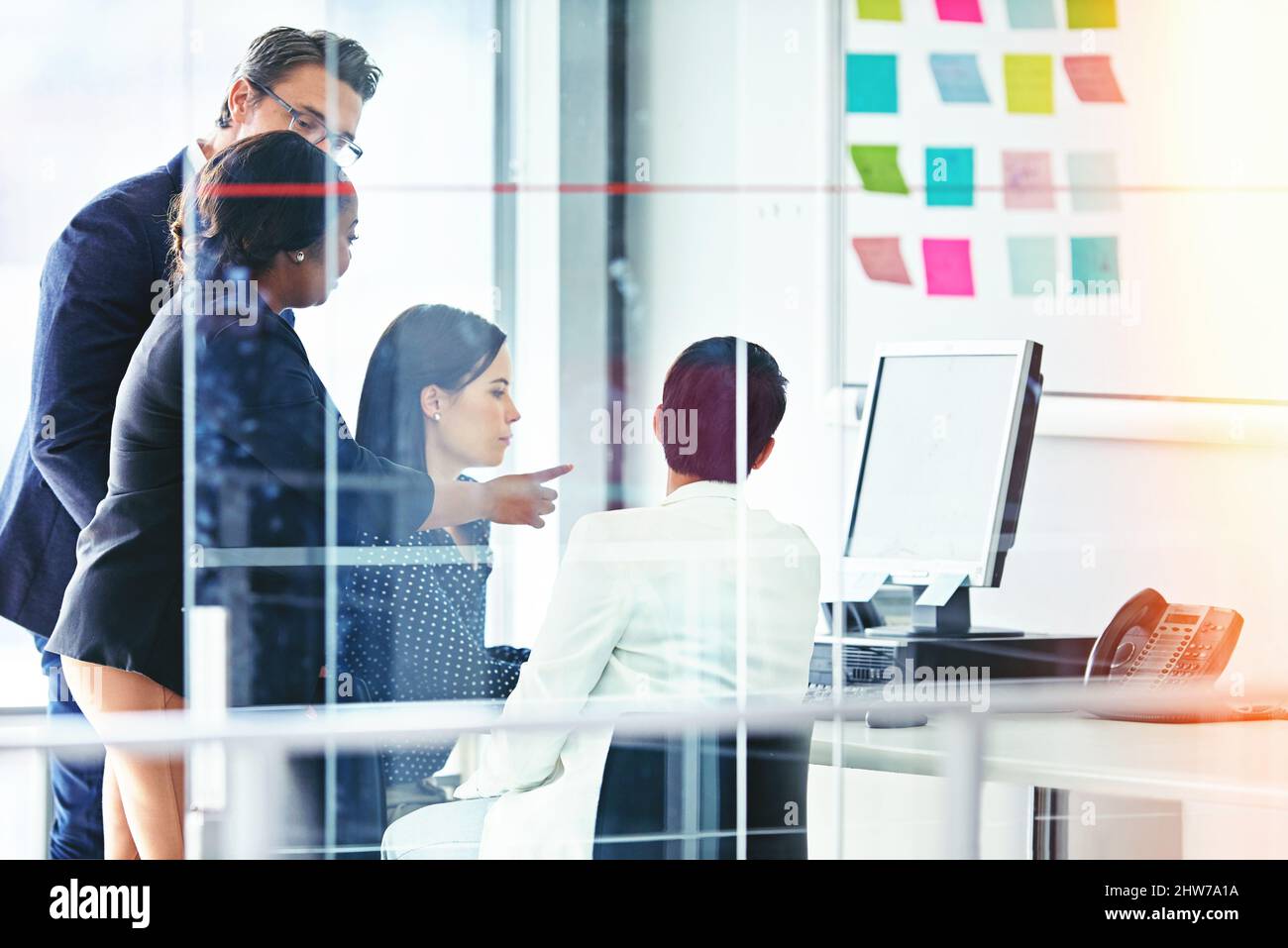 Taking a closer look. Cropped shot of four business colleagues working ...
