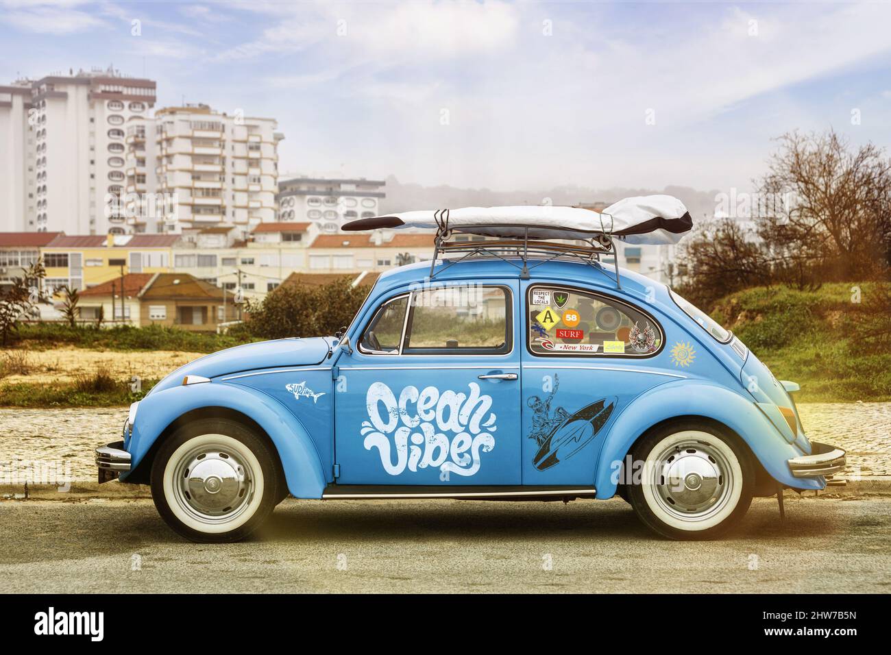 Blue surfer car parked on the beach of Costa Caparica, Lisbon, Portugal ...