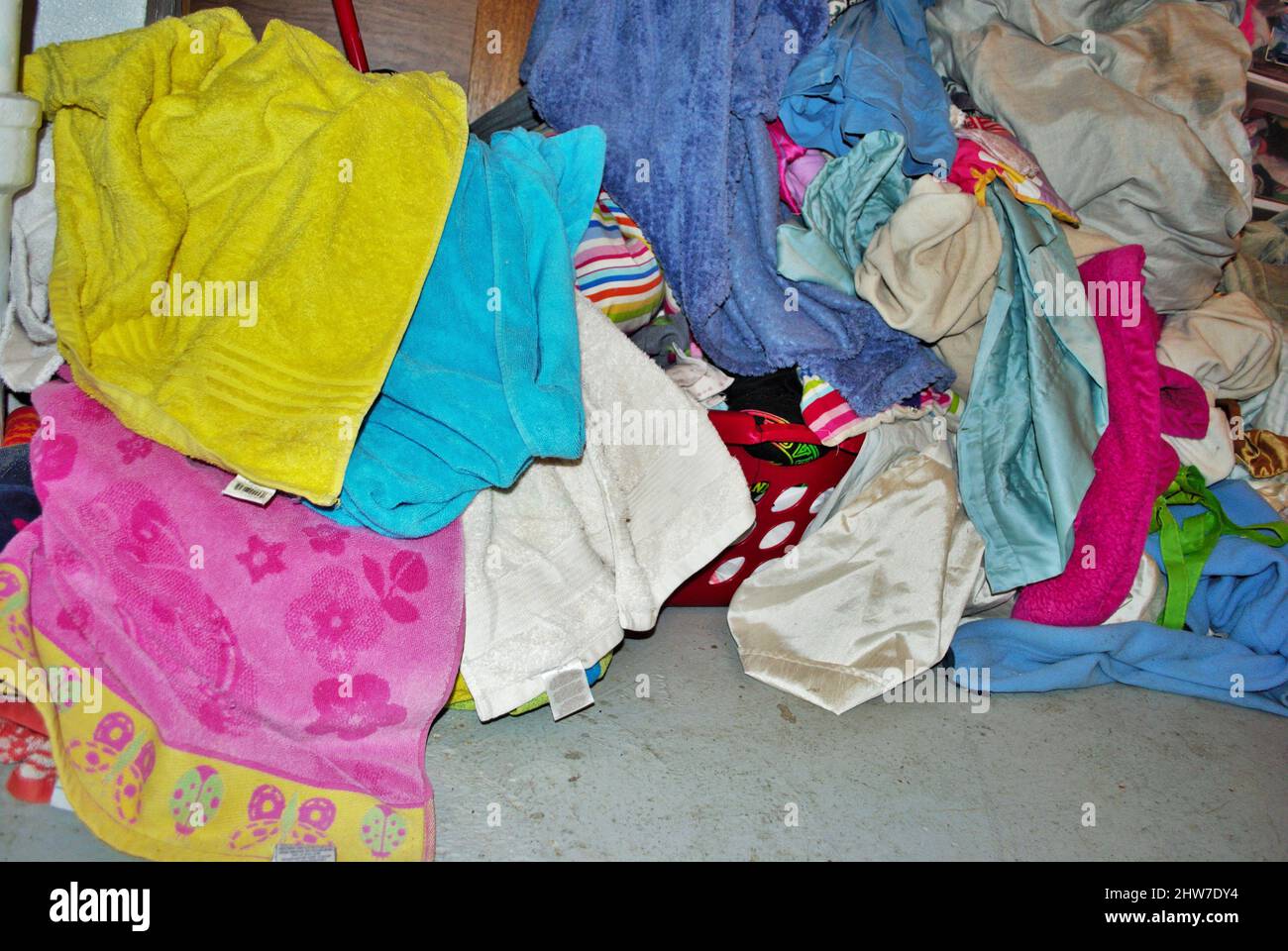 Pile of dirty towels that need to be washed in a basement laundry room ...