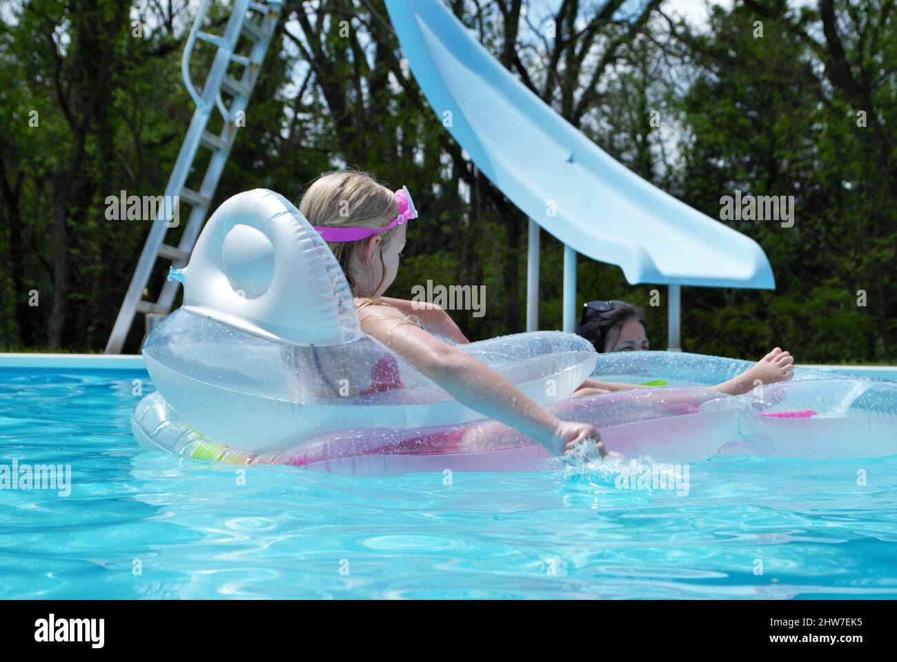 young girl floating on an inflatable in the pool Stock Photo - Alamy