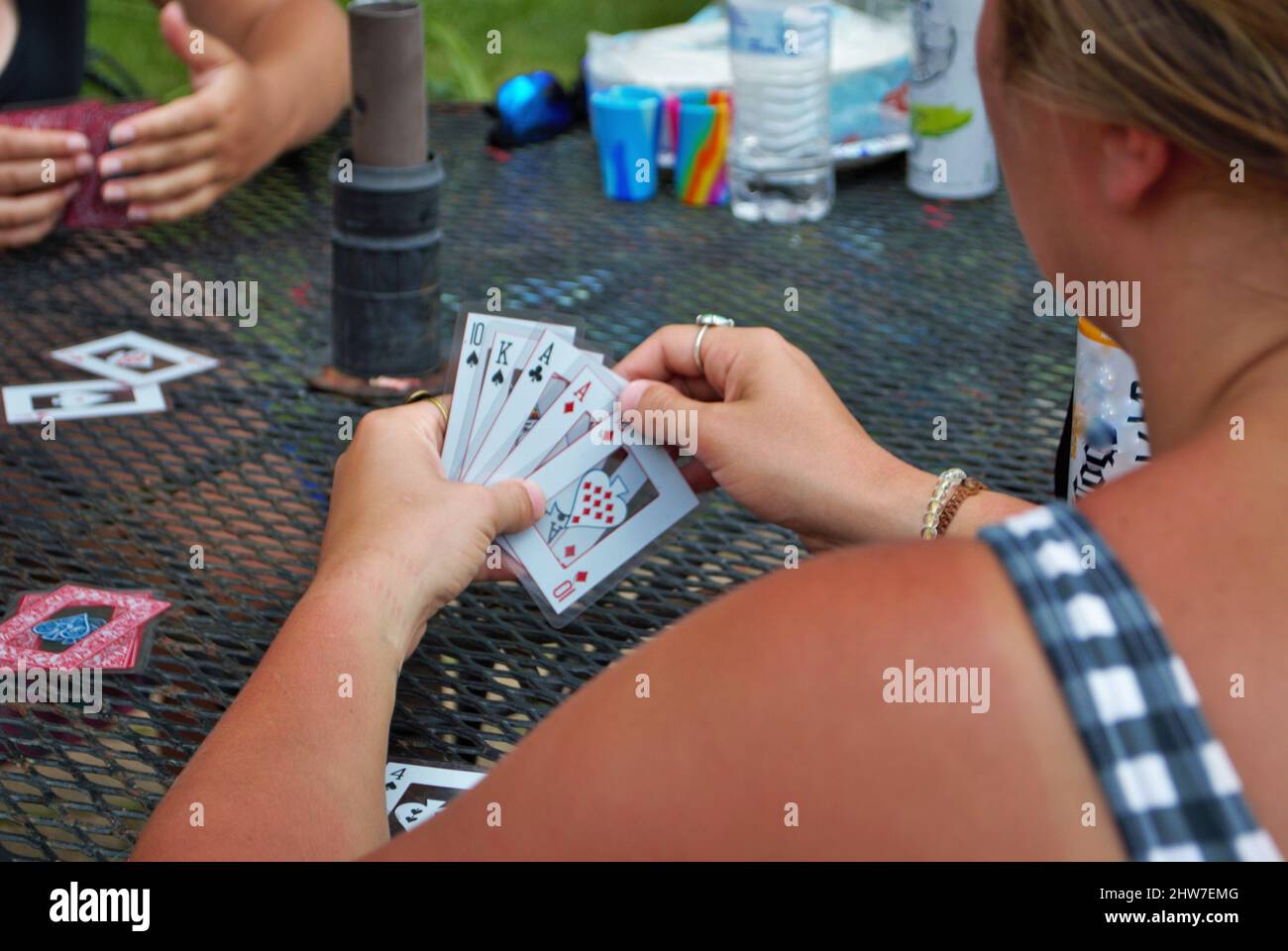 Over the shoulder view of a young woman playing cards Stock Photo - Alamy