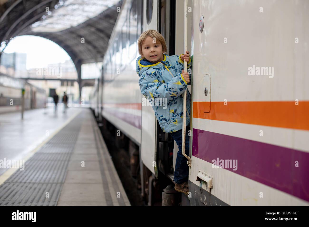 Cute little child tourists, standing on the stairs of a train in ...
