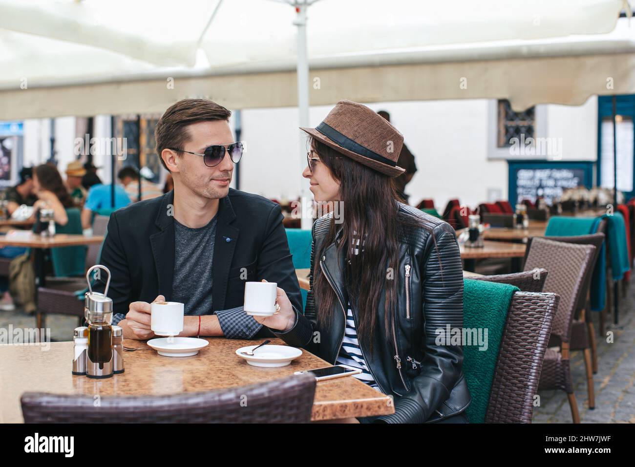 Two people drinking coffee in outdoor cafe enjoying the time spending ...
