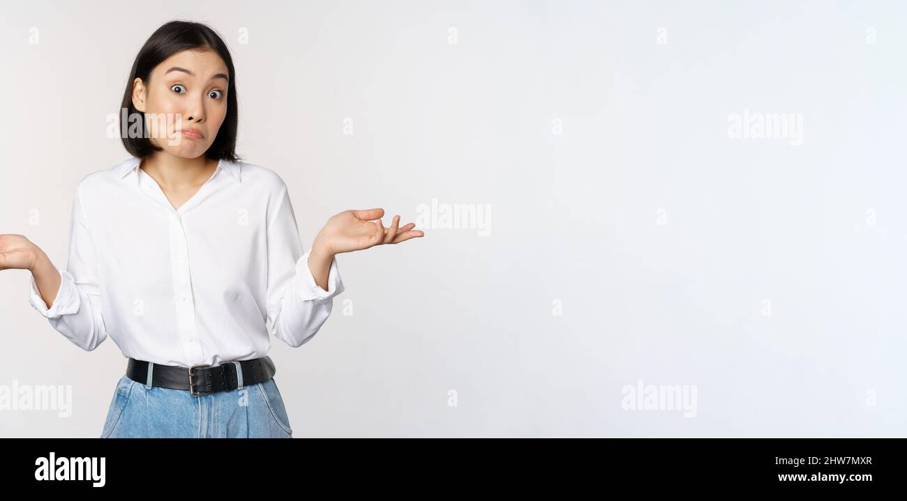 Image of confused asian office manager, office lady shrugging shoulders ...
