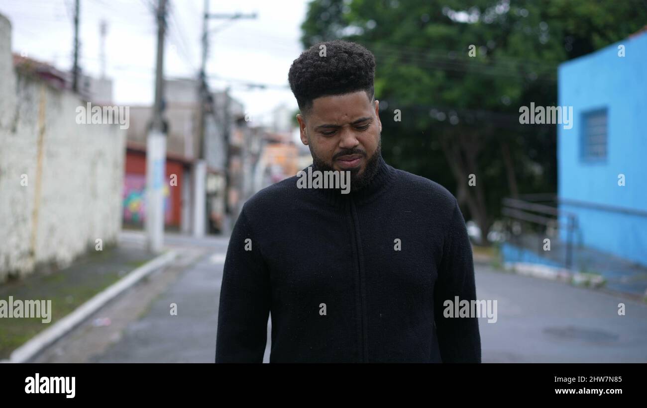 A diverse young black man walking forward in urban street Stock Photo ...