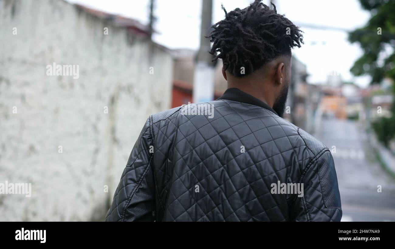 A pensive young black man walking outside in urban street a thoughtful ...