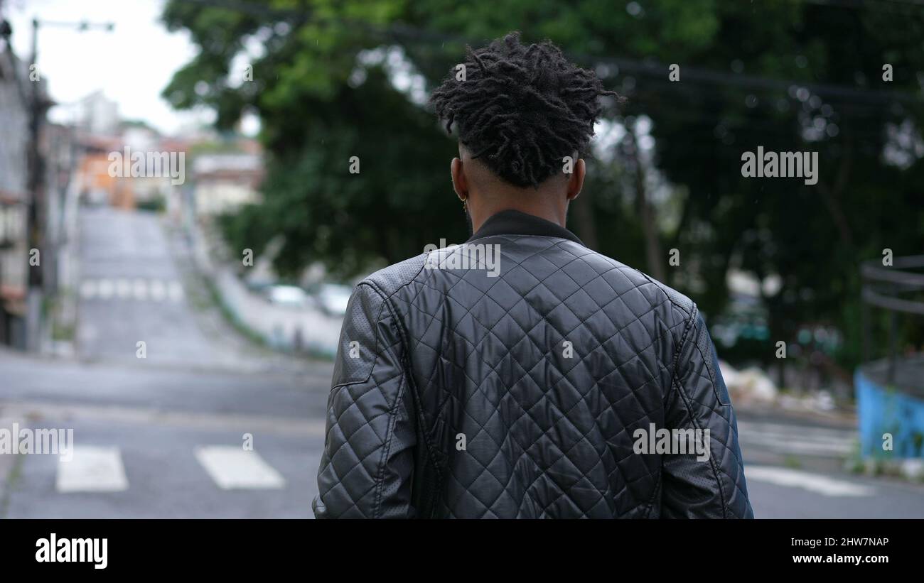 A pensive young black man walking outside in urban street a thoughtful ...