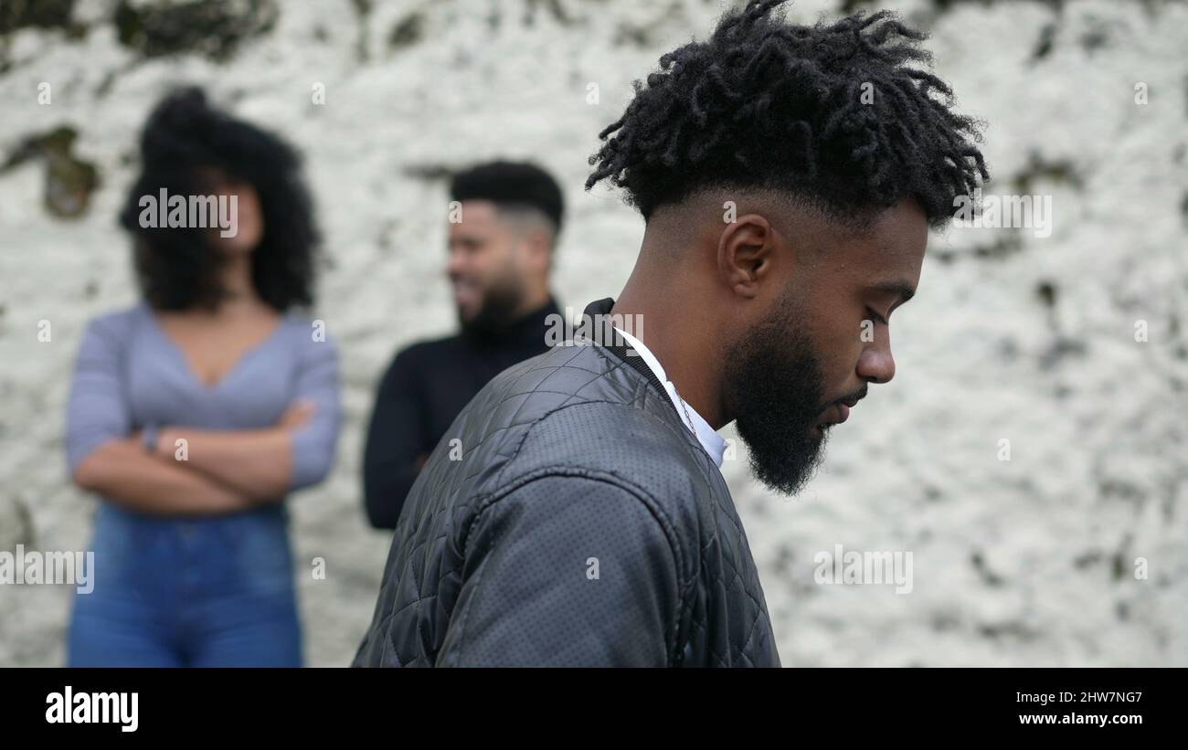 A pensive young black man walking outside in urban street a thoughtful ...