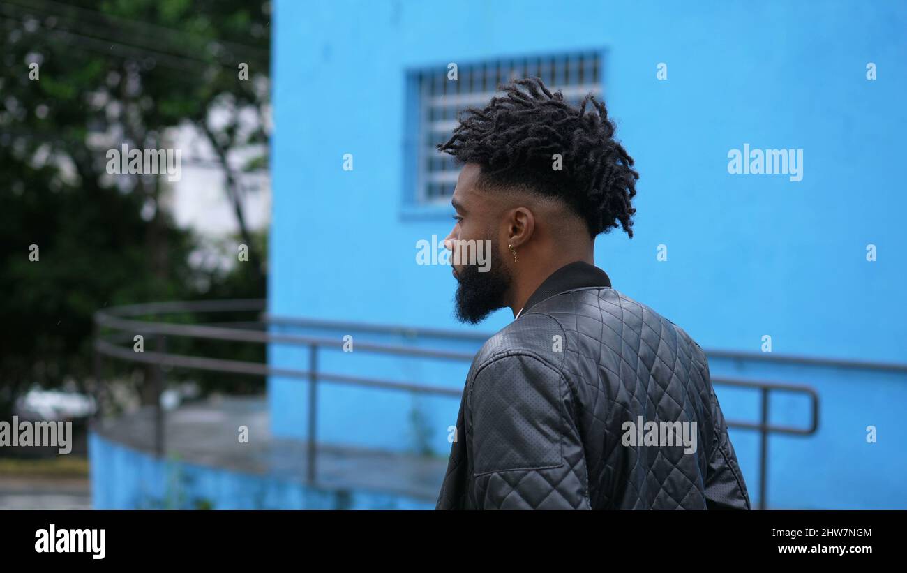 A pensive young black man walking outside in urban street a thoughtful ...