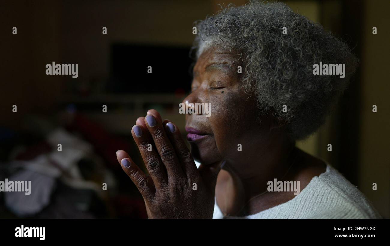 A senior African woman praying to God in meditation Stock Photo - Alamy