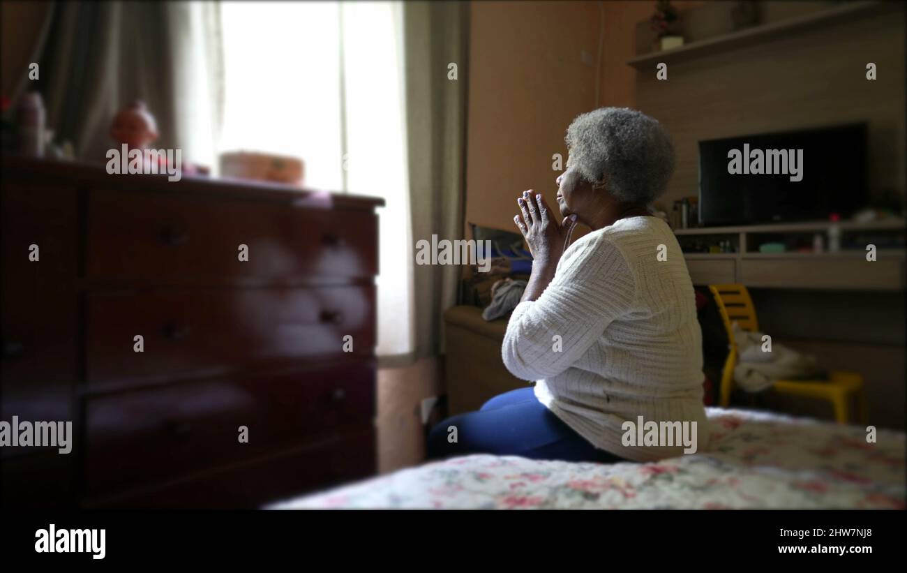 A spiritual older black woman praying to God sitting in bedroom Stock ...
