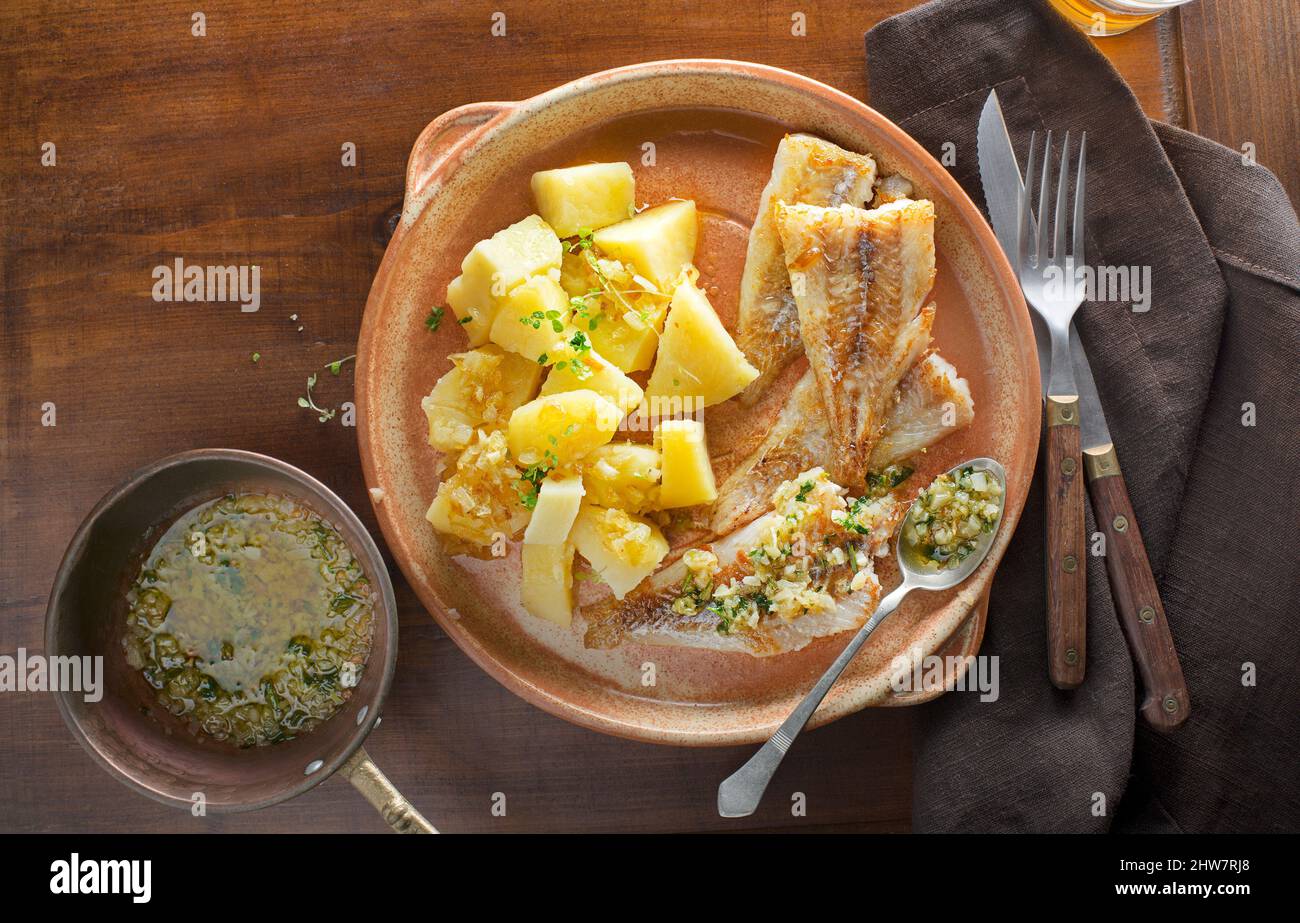 Fish dish - fried cod fillet with boiled potatoes on wooden table ...