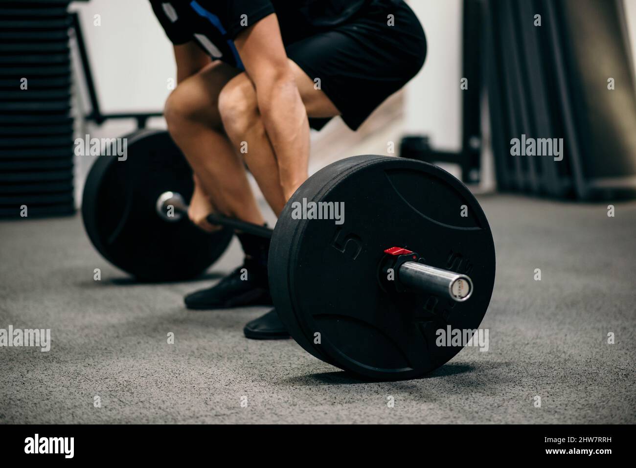 Training man at the gym lifting a barbell Stock Photo - Alamy