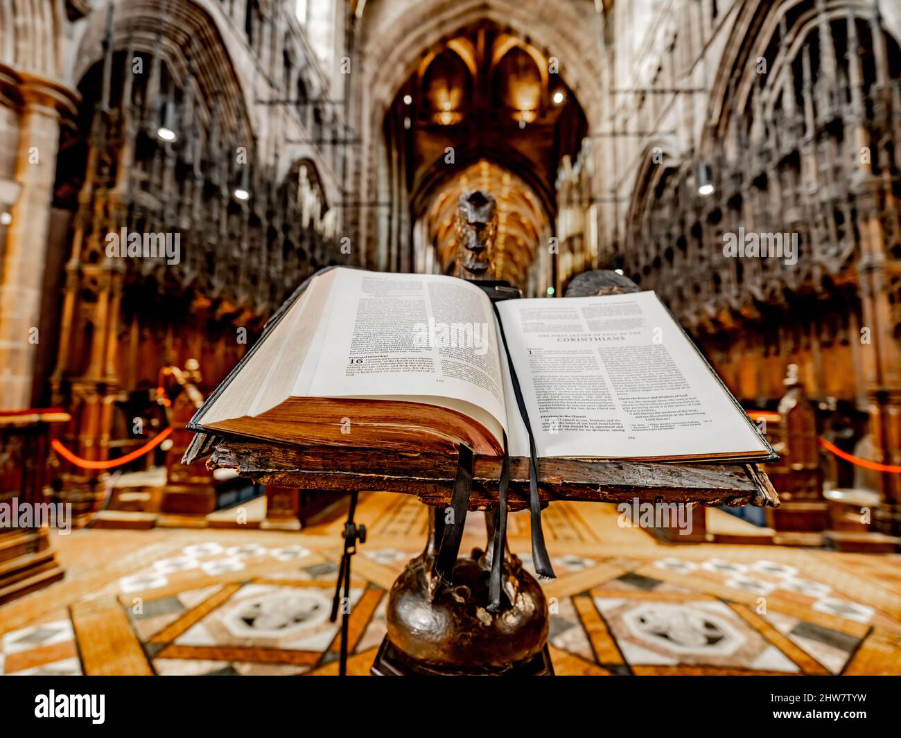 A bible rest on a old wooden lectern open on 1 Corinthians within the ...